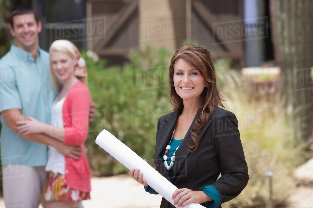 Realtor with couple outside home - Stock Photo - Dissolve