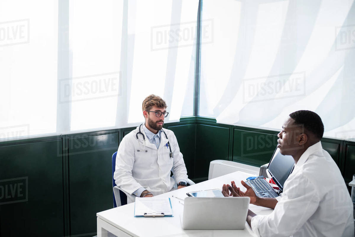 Doctors having discussion in meeting room - Stock Photo - Dissolve