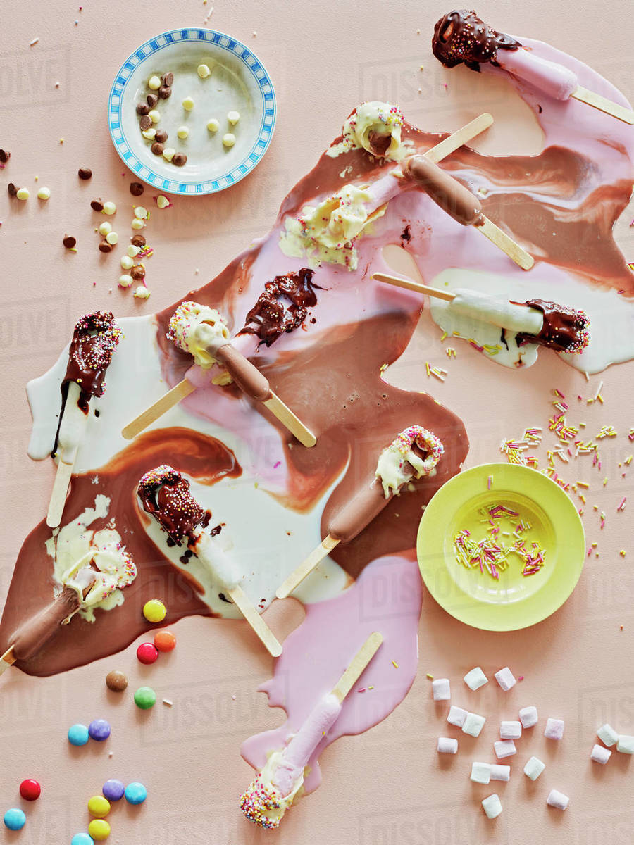Chocolate top ice lollies melting and sprinkles on table - Stock Photo ...