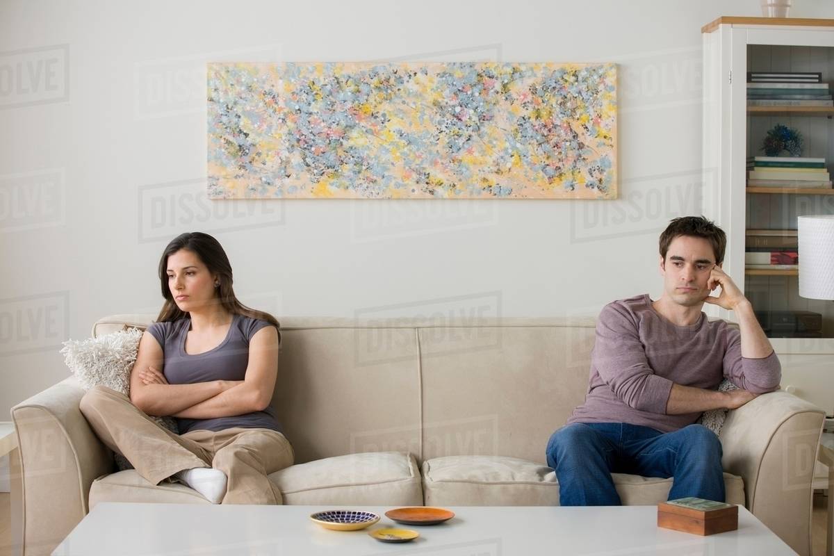 Couple sitting on sofa ignoring each other - Royalty-free Stock Photo ...