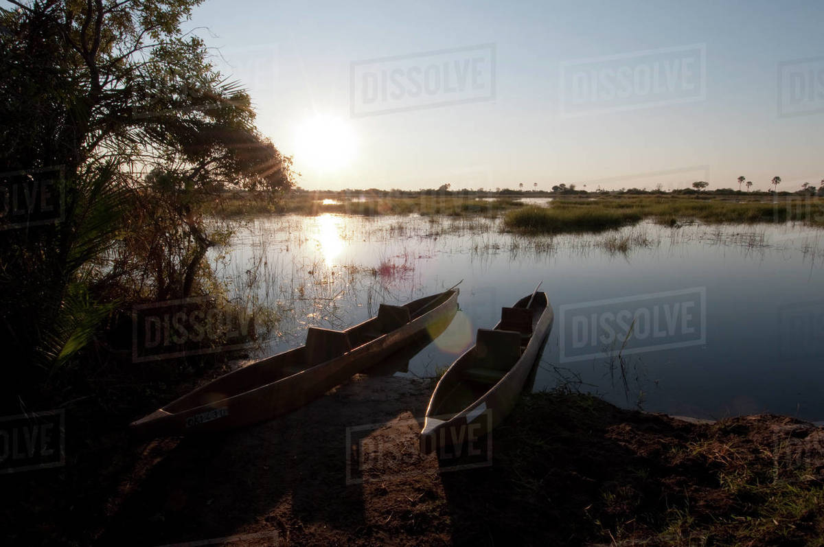 Two boats on riverbank, Abu Camp, Okavango Delta, Botswana - Royalty ...
