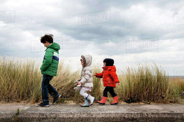 Siblings exploring beach - Royalty-free Stock Photo | Dissolve