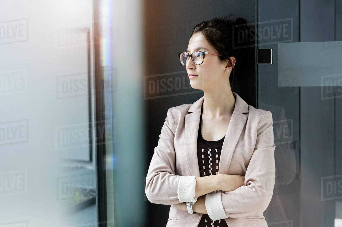 Portrait of young businesswoman with dark brown hair wearing glasses ...