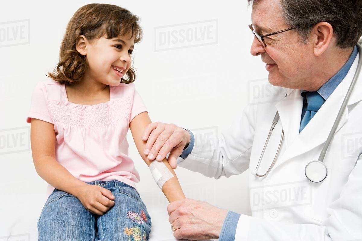Doctor putting plaster on girl - Royalty-free Stock Photo | Dissolve