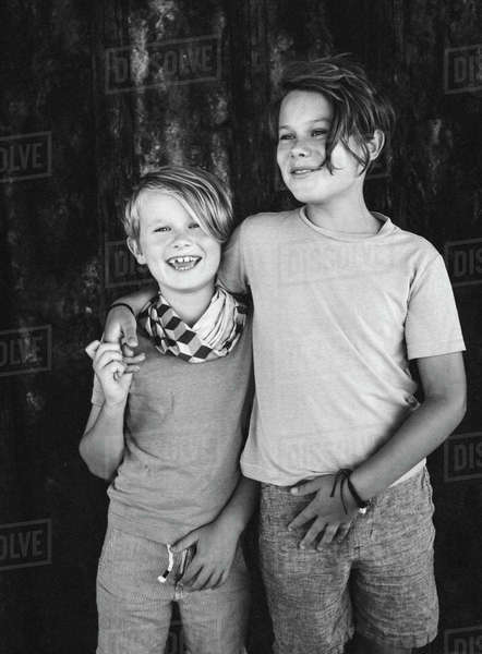Portrait of two smiling boys, arm around shoulder, looking at camera ...