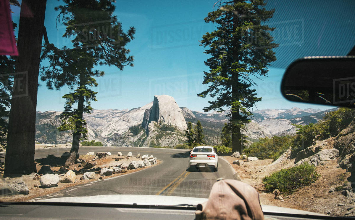 Cars traveling on rural road through Yosemite National Park, California ...
