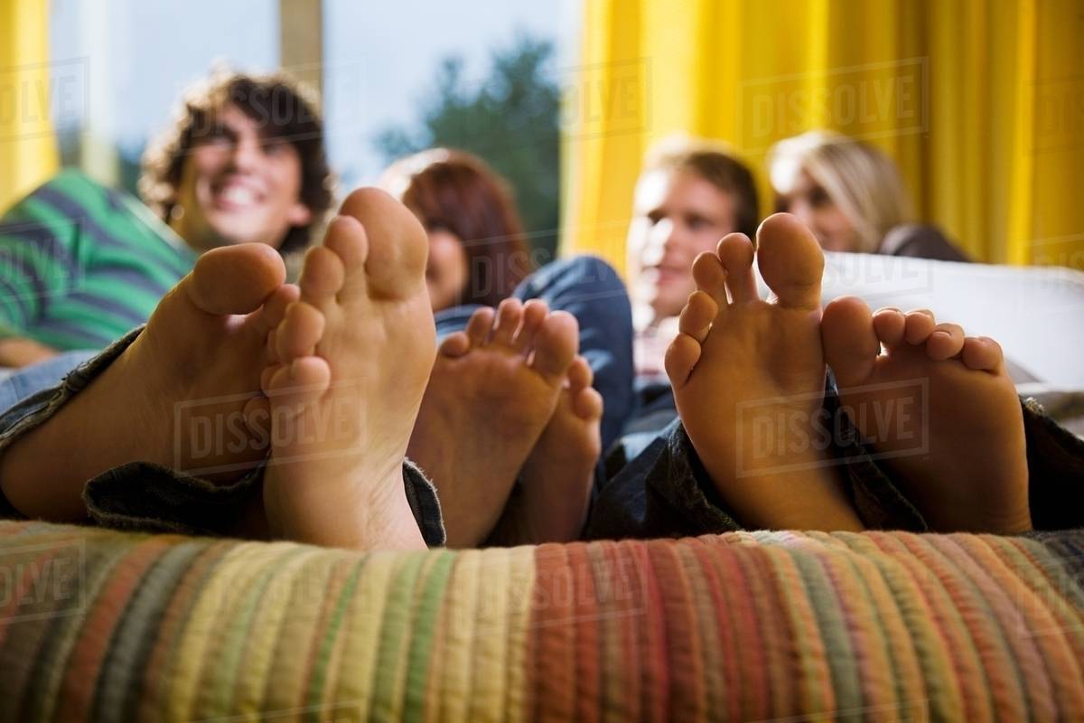 Friends on bed with bare feet - Royalty-free Stock Photo | Dissolve