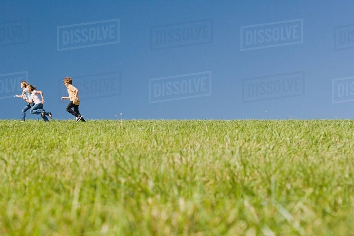 Children running in field - Royalty-free Stock Photo | Dissolve