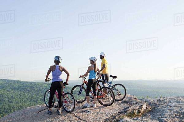Three cyclists looking at view - Royalty-free Stock Photo | Dissolve