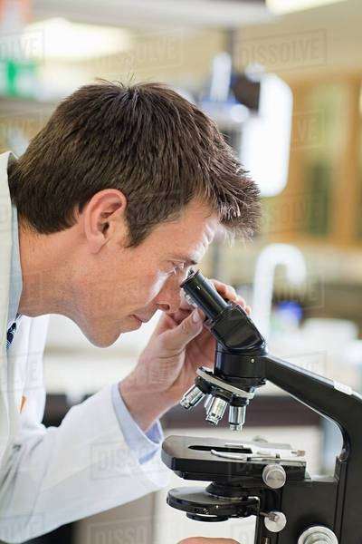 Doctor using microscope - Stock Photo - Dissolve