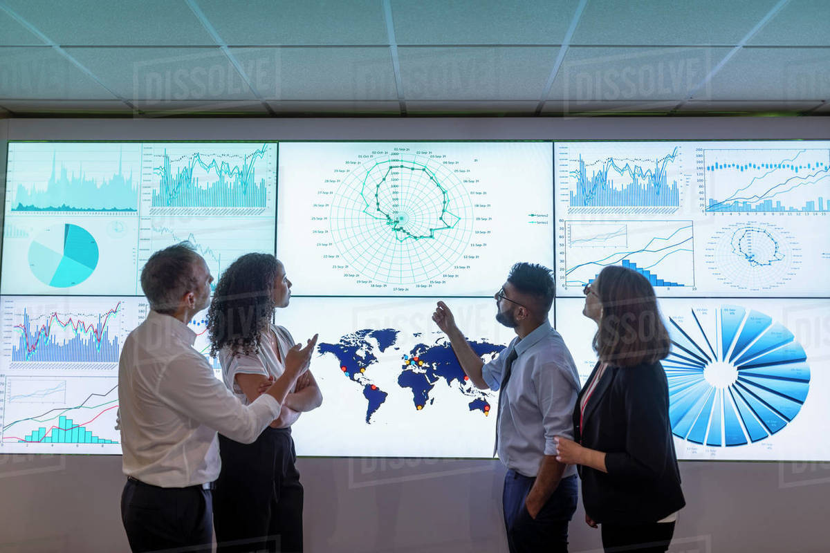 Business people discussing charts on interactive screens - Stock Photo ...