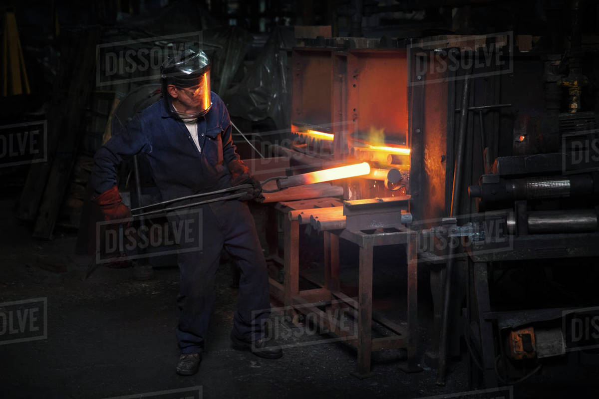 Forge worker pre heating steel billet for forging - Royalty-free Stock ...