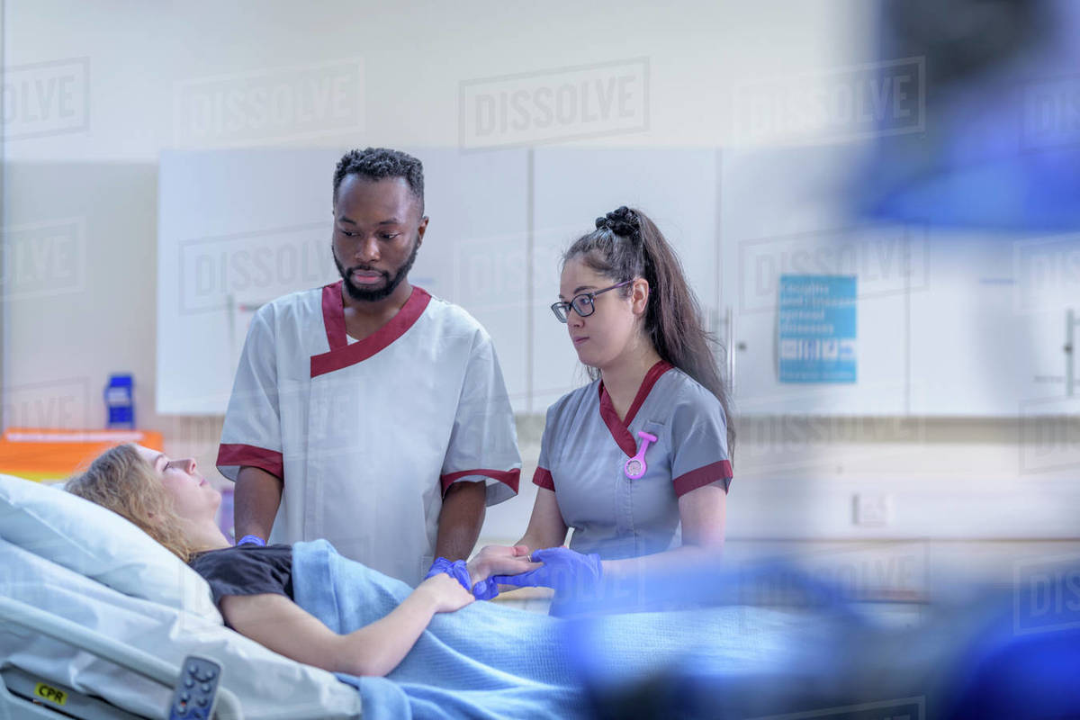 Nurses with patient in hospital ward - Stock Photo - Dissolve