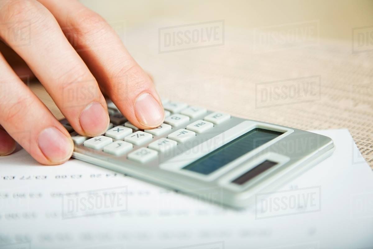 Office worker using calculator - Stock Photo - Dissolve