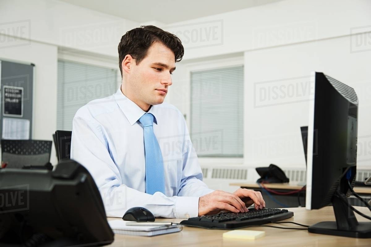 Office worker using computer - Stock Photo - Dissolve