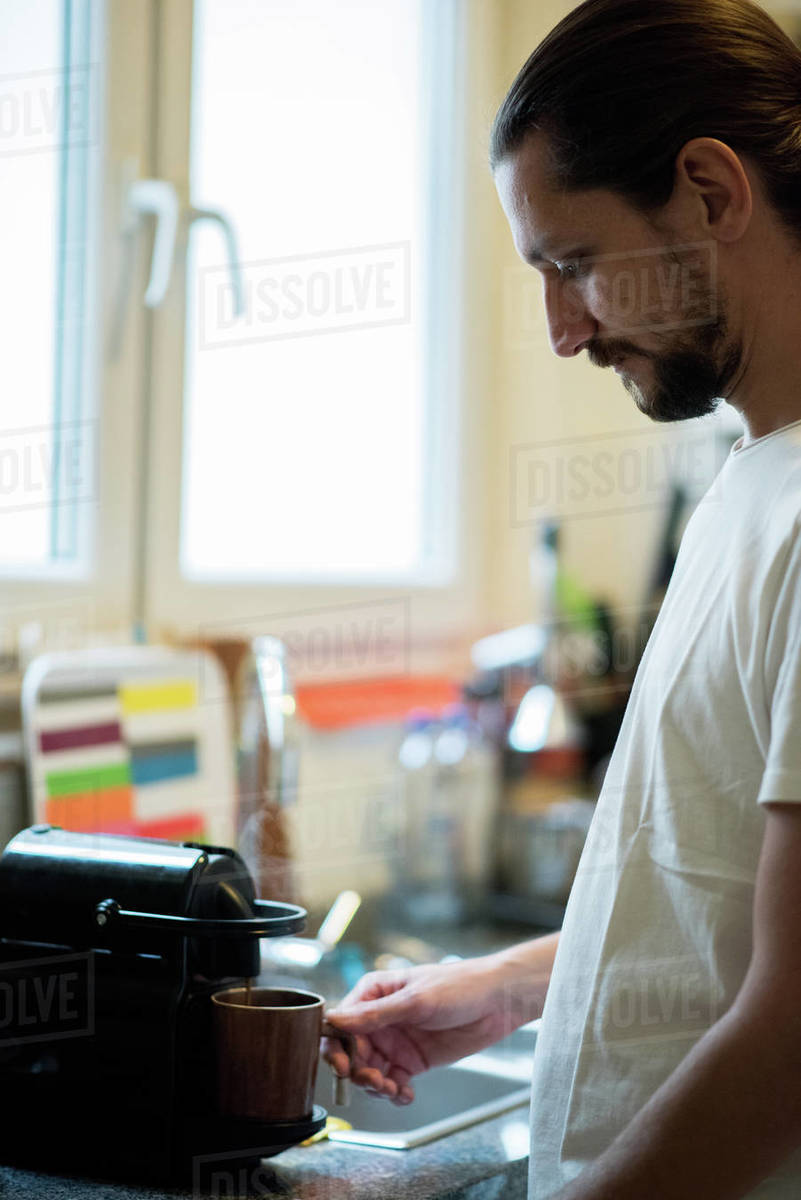 Man making coffee in kitchen - Royalty-free Stock Photo | Dissolve