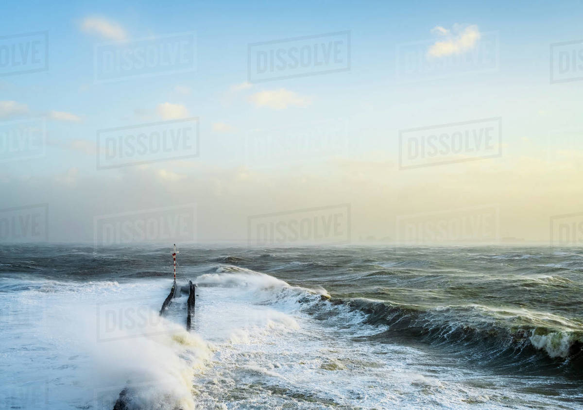Netherlands, Vlissingen, Sea waves crashing against pier during storm ...