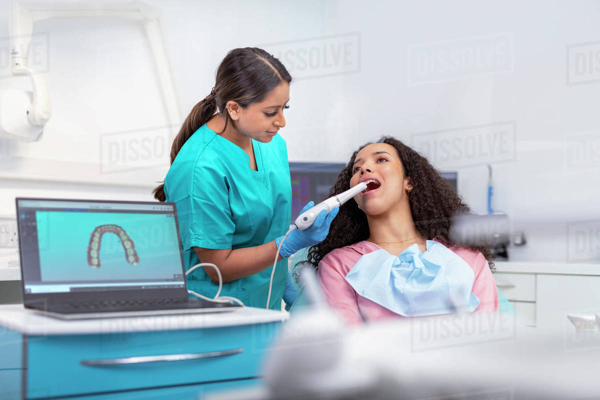 Nurse with patient using intraoral scanner which scans teeth to make 3D ...