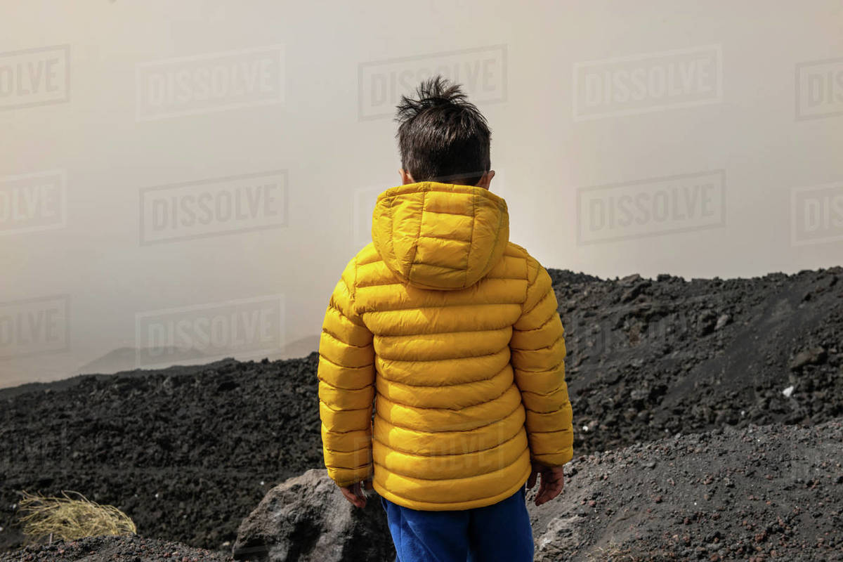 Italy, Sicily, Boy looking at Etna volcano - Stock Photo - Dissolve