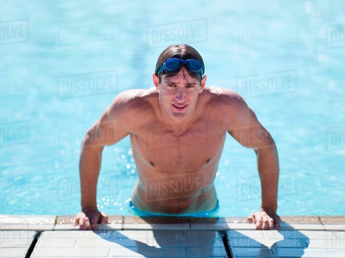 Young man exiting swimming pool - Royalty-free Stock Photo | Dissolve