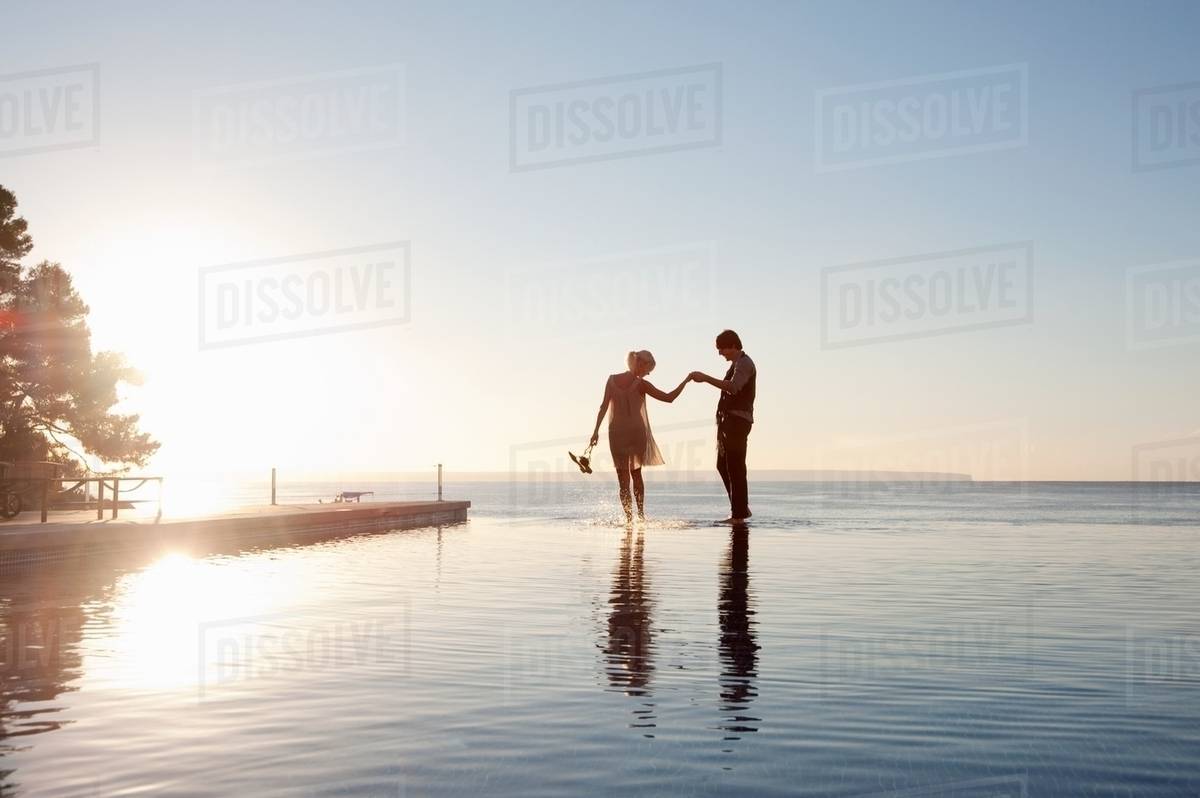 Couple in the ocean at sunset - Stock Photo - Dissolve