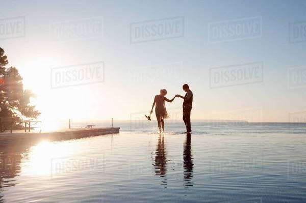 Couple in the ocean at sunset - Stock Photo - Dissolve