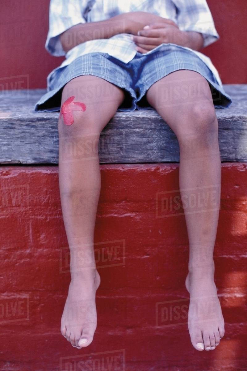 Boy with injured knee - Stock Photo - Dissolve