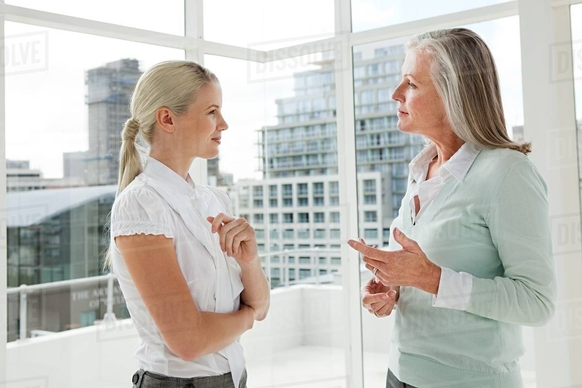 Two businesswomen talking in office - Royalty-free Stock Photo | Dissolve
