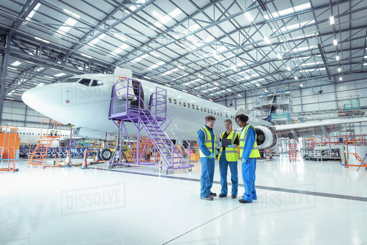 Aircraft maintenance engineers talking at aircraft in maintenance ...
