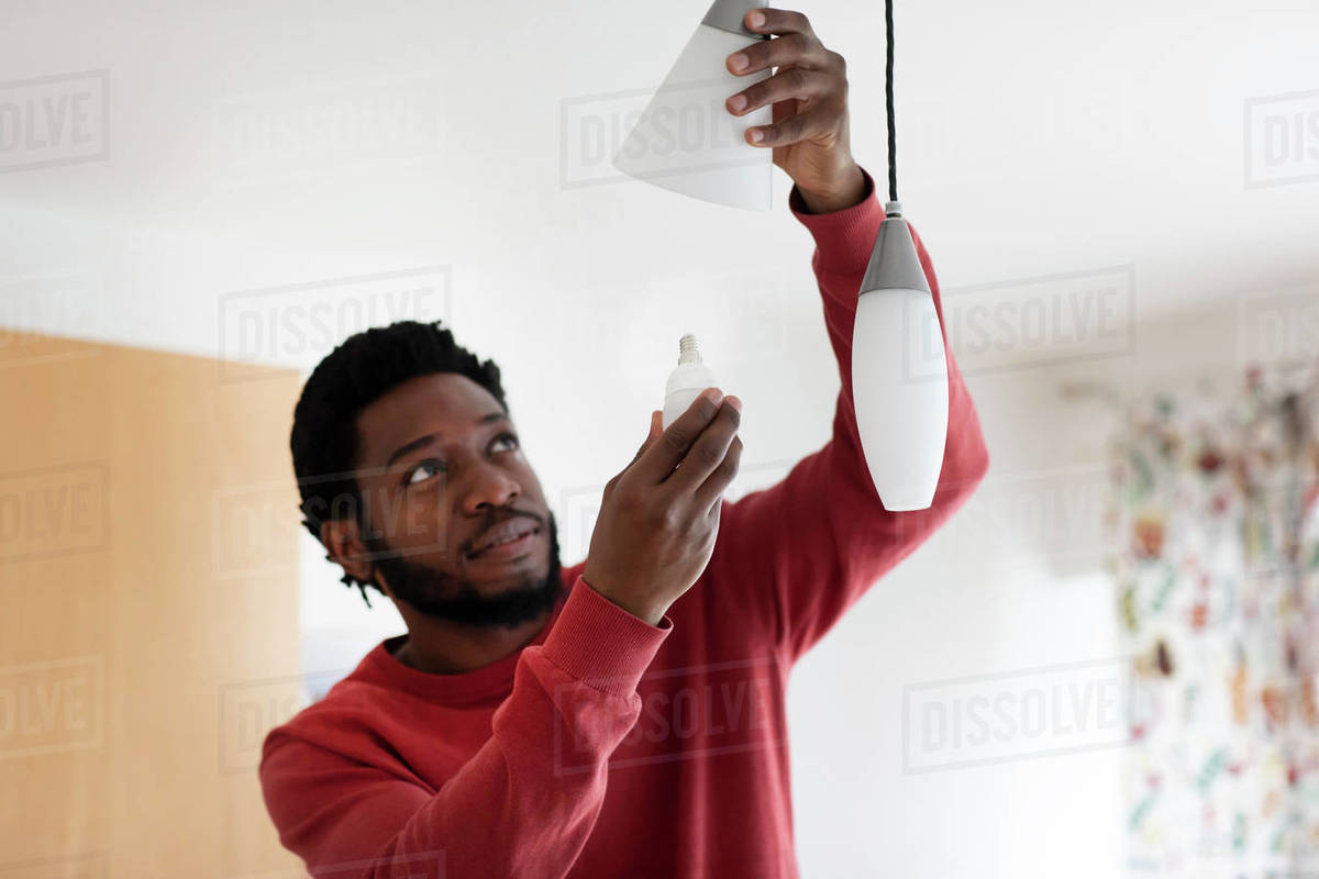 Young man changing bulb in electric light - Royalty-free Stock Photo ...