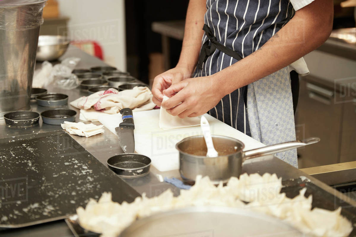 Male cook working in kitchen - Royalty-free Stock Photo | Dissolve