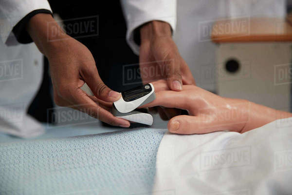 Medical student using pulse oximeter on dummy - Stock Photo - Dissolve
