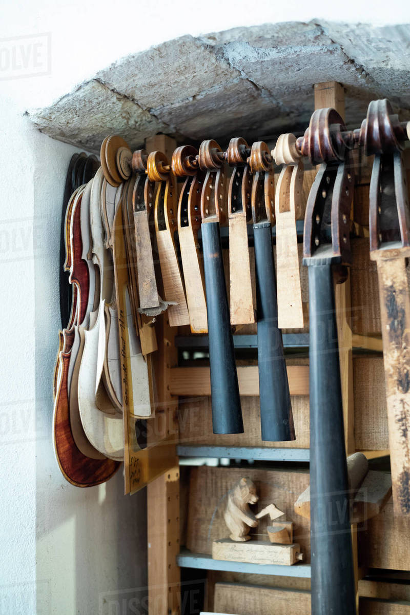 Violin parts hanging in workshop - Stock Photo - Dissolve
