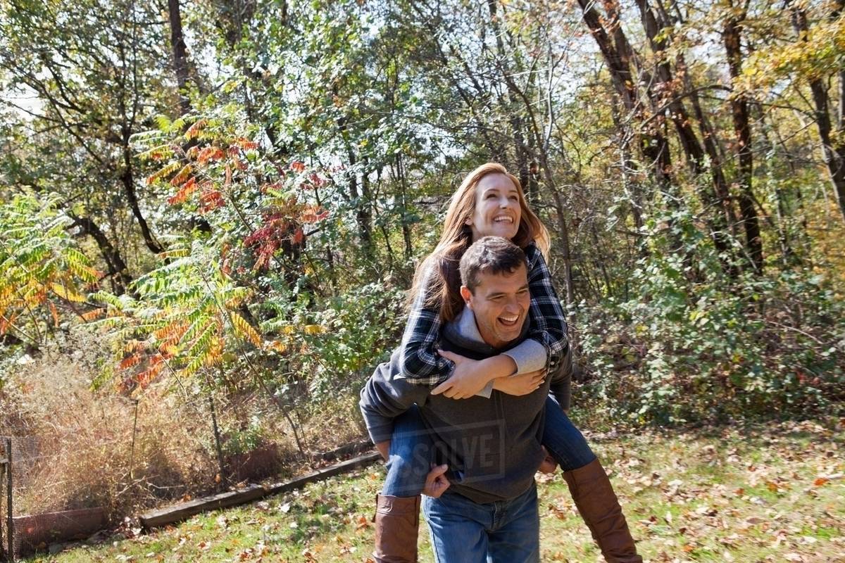 Couple piggybacking outdoors - Royalty-free Stock Photo | Dissolve