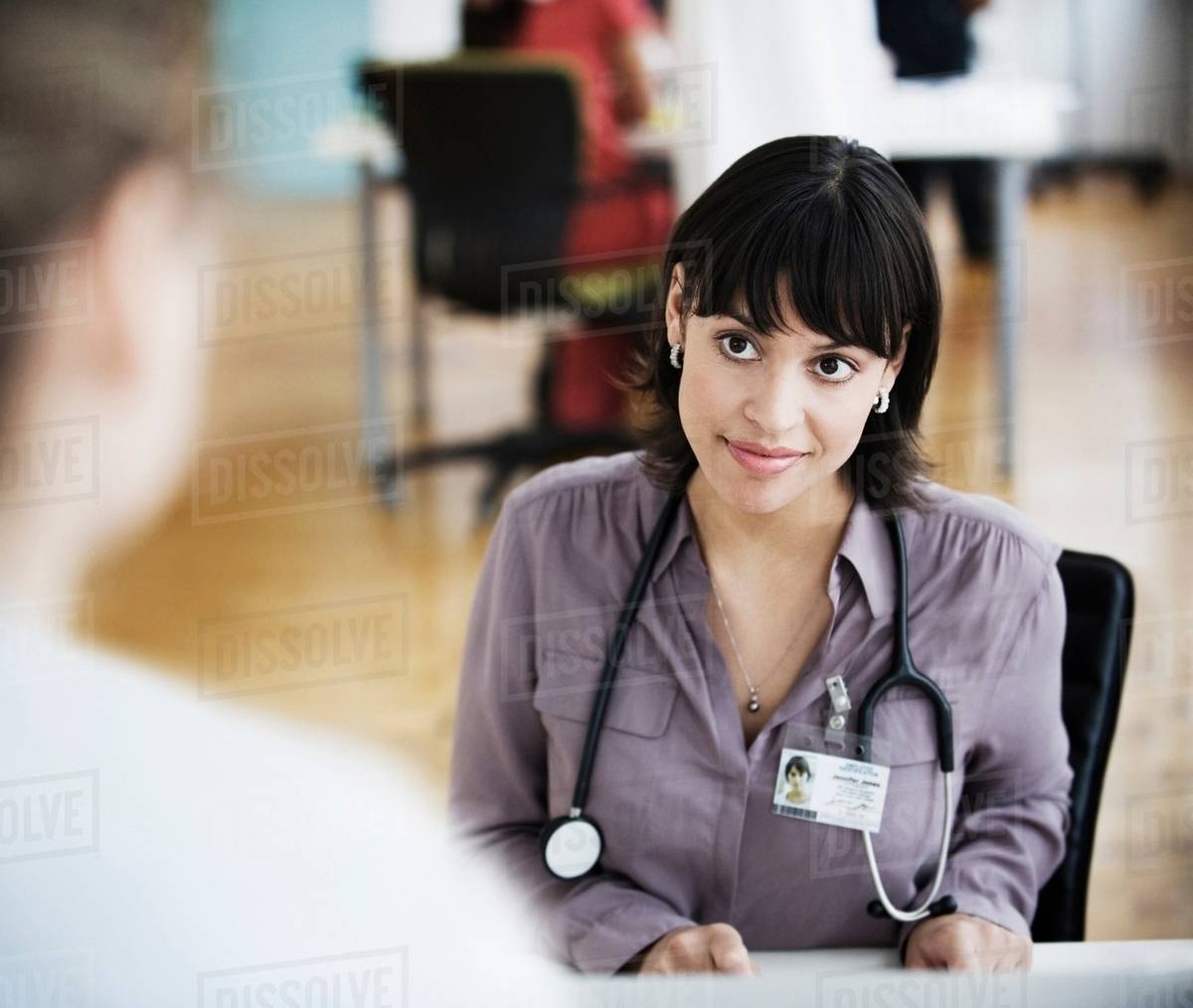 Doctor sitting at desk - Royalty-free Stock Photo | Dissolve