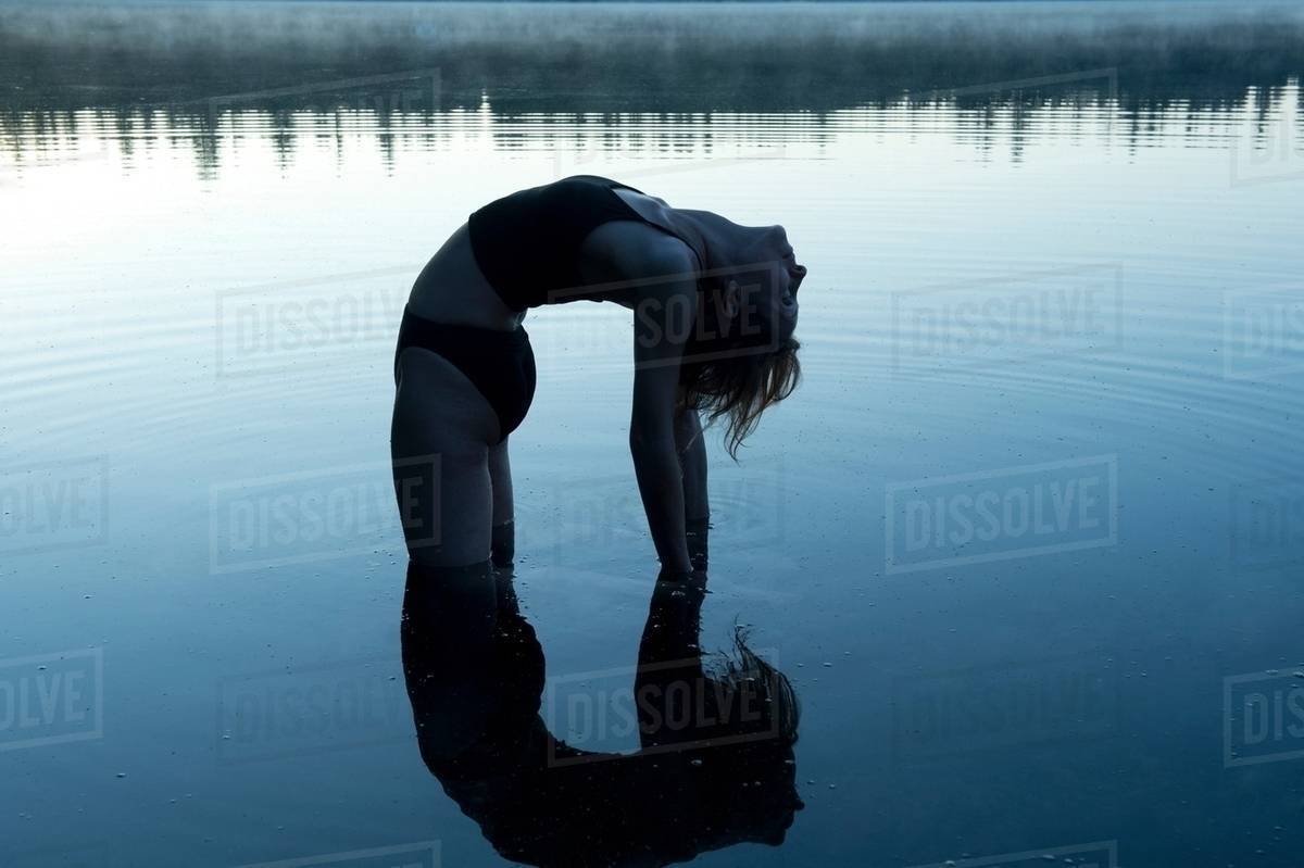 Woman bending backwards in lake - Royalty-free Stock Photo | Dissolve