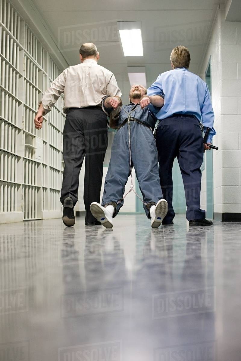 Prisoner being dragged down corridor - Stock Photo - Dissolve