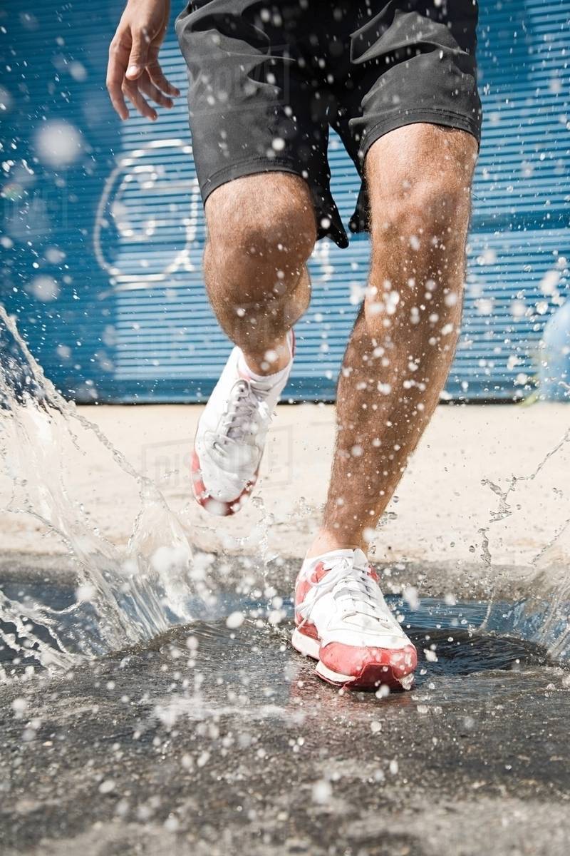 Runner stepping in puddle - Royalty-free Stock Photo | Dissolve