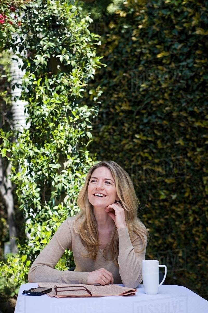 Woman at table outdoors - Stock Photo - Dissolve