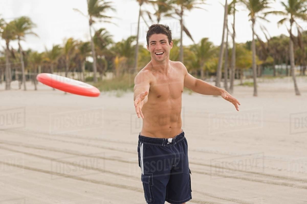 Young man throwing flying disc - Stock Photo - Dissolve