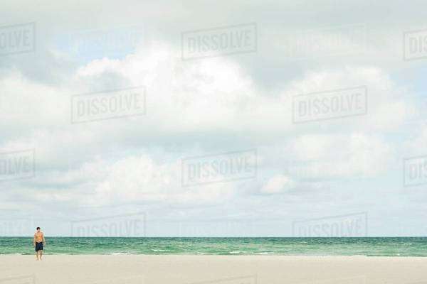 Man on beach by the sea - Royalty-free Stock Photo | Dissolve