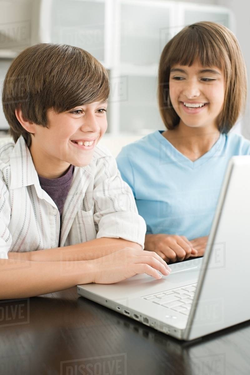Brother and sister using a laptop computer - Stock Photo - Dissolve