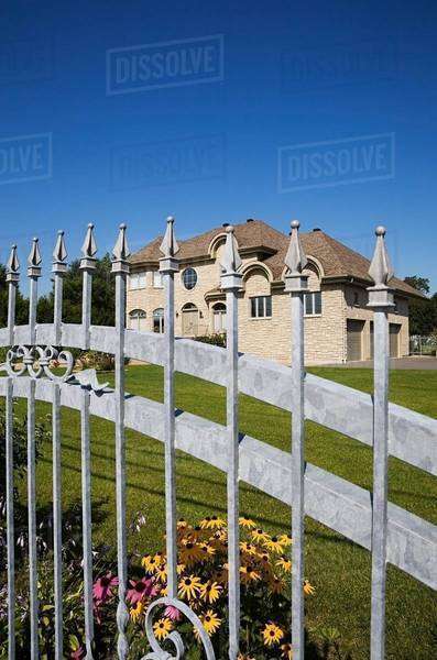 Large house behind gate - Stock Photo - Dissolve