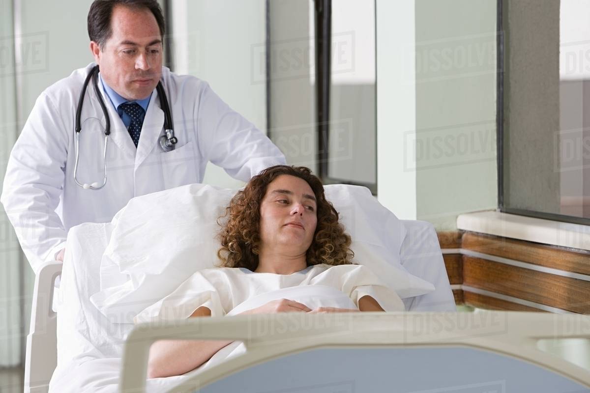 Doctor pushing patient in bed - Royalty-free Stock Photo | Dissolve