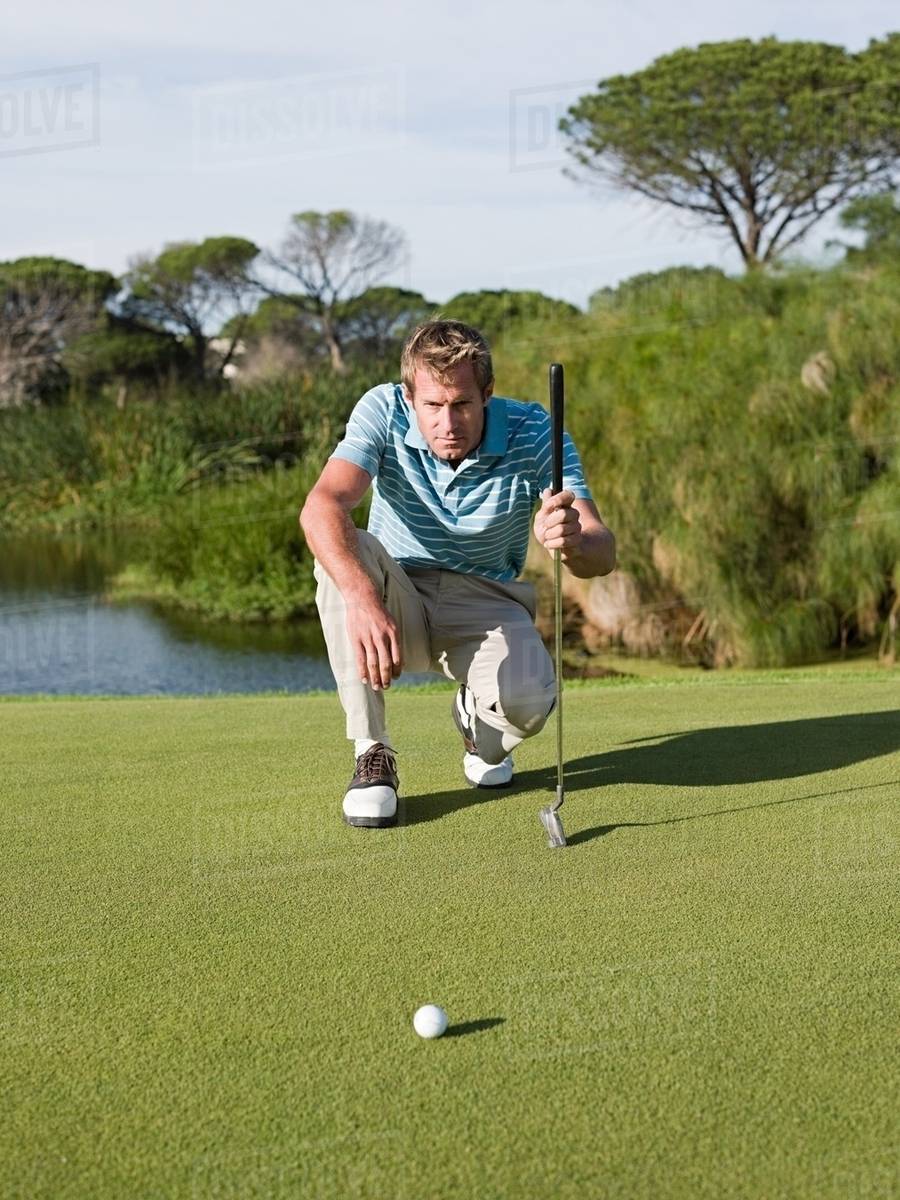 Man playing golf, on putting green - Royalty-free Stock Photo | Dissolve