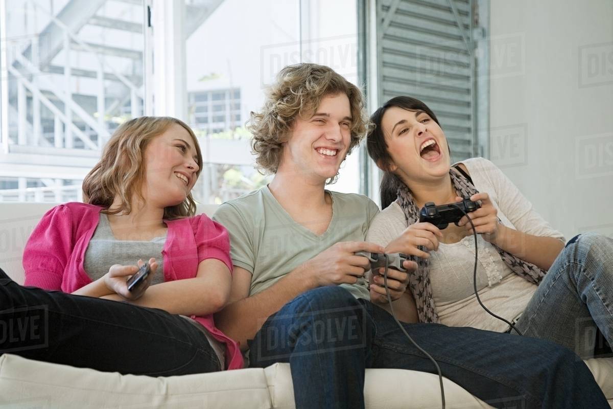 Teenagers playing on games console - Stock Photo - Dissolve