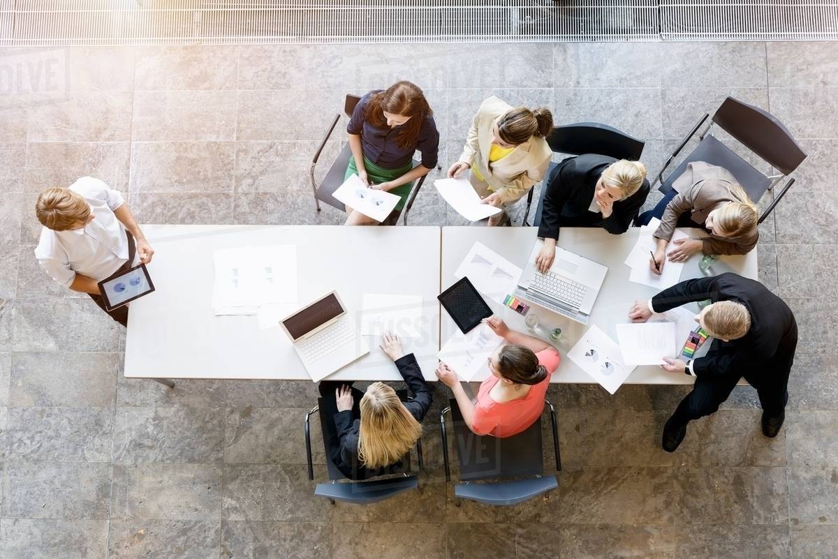 Overhead view of business team meeting at desk in office - Stock Photo ...