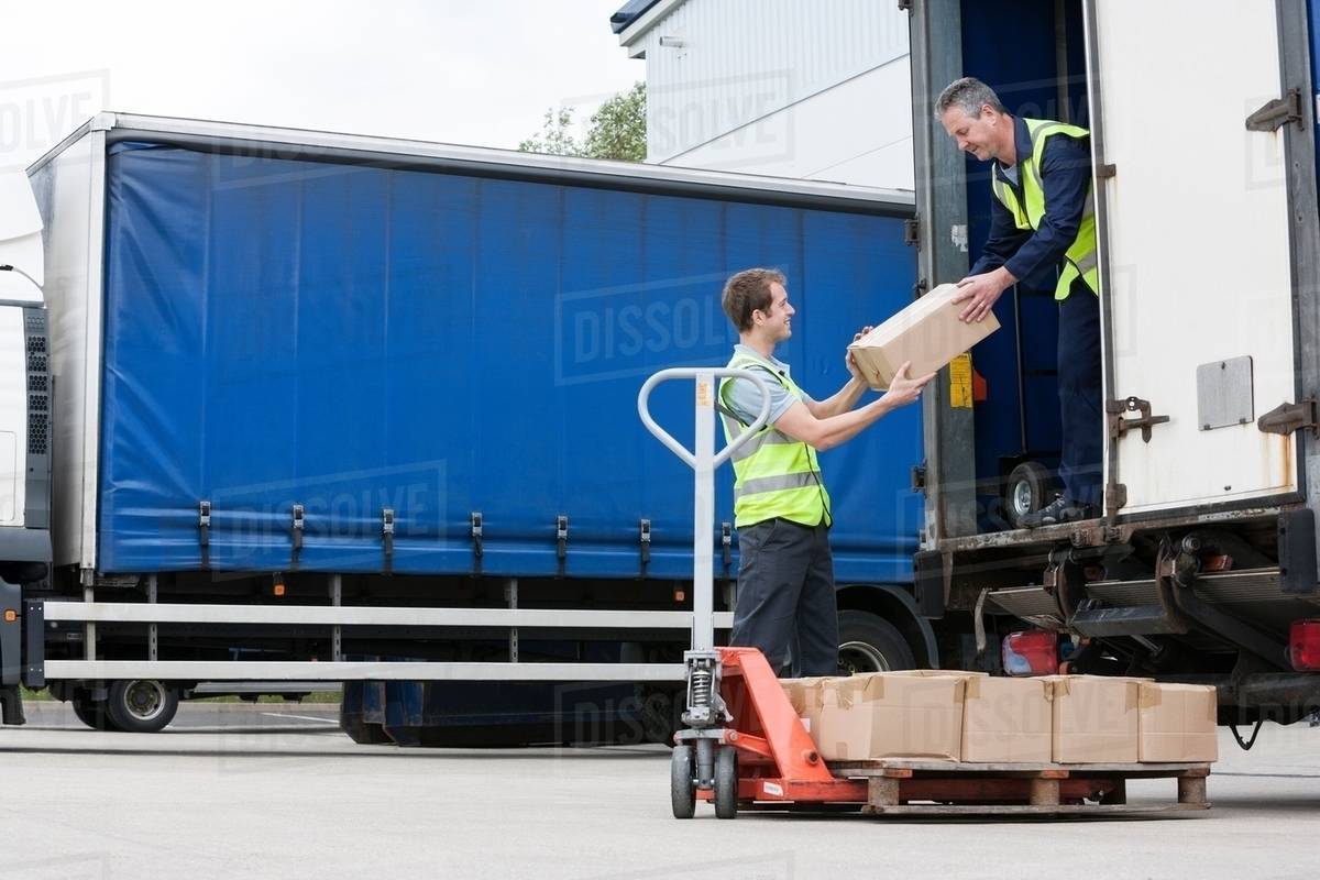 Two men unloading cardboard boxes from truck - Royalty-free Stock Photo ...