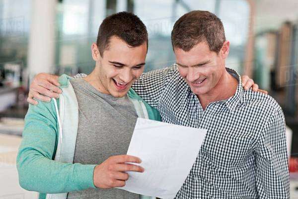 Two men reading document, arms around each other - Royalty-free Stock ...