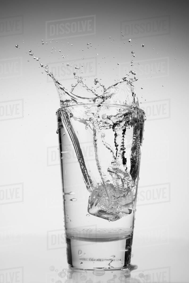 Ice cube falling into glass of water - Royalty-free Stock Photo | Dissolve